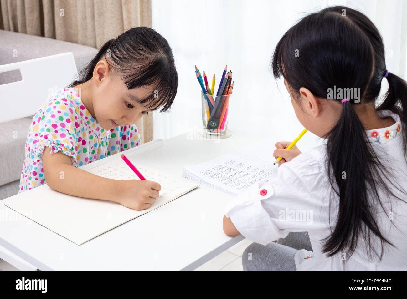 Asian Little Chinese sisters doing homework at home Stock Photo - Alamy