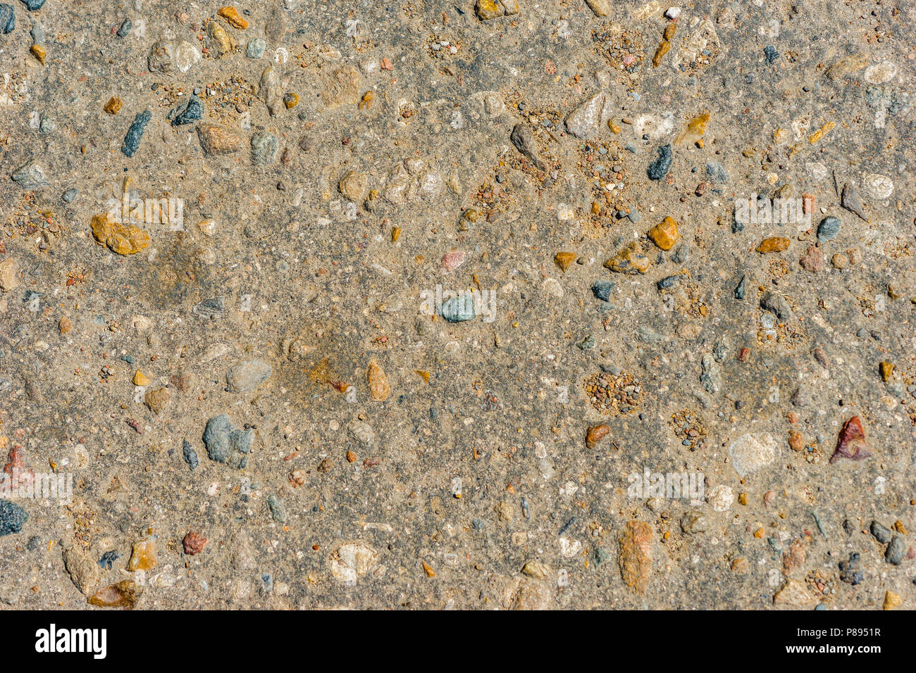 Closeup view of a concrete texture pattern with colorful pebbles or ...