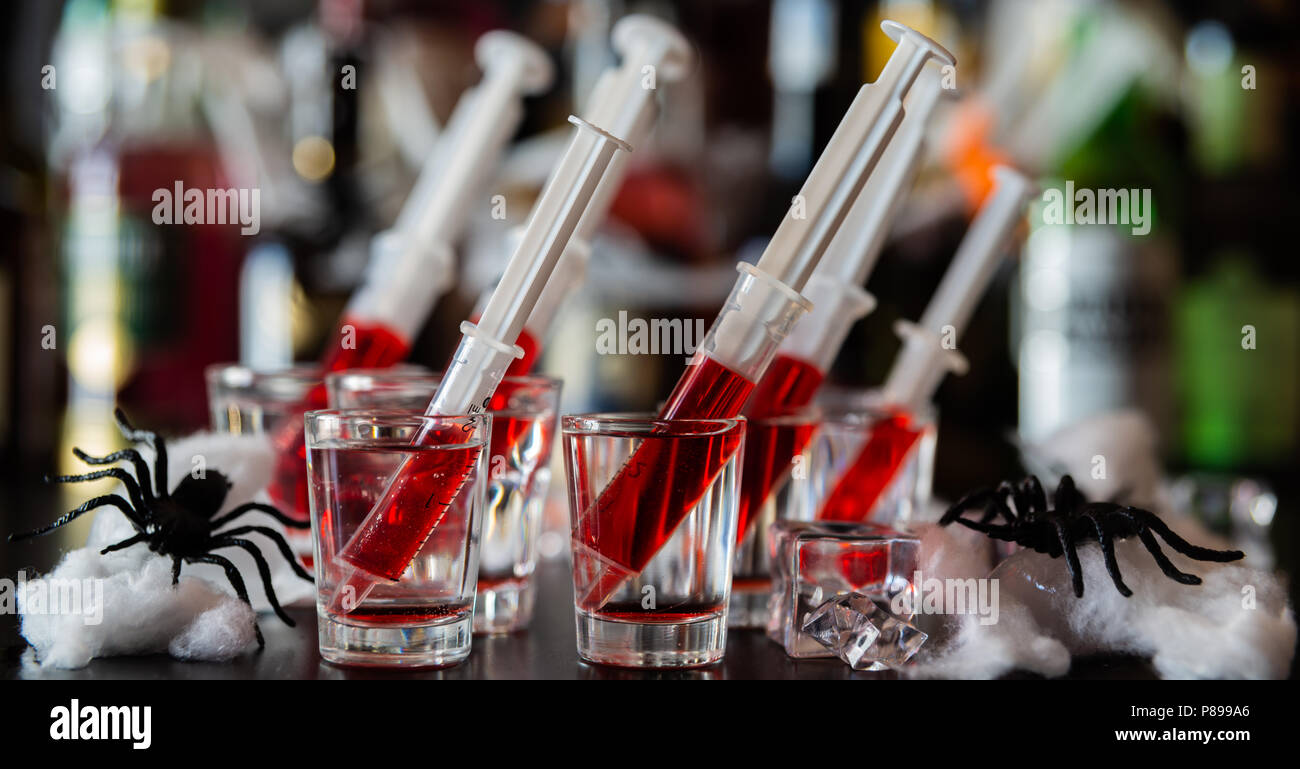 creepy halloween party cocktails with syringes of grenadine syrup as ...