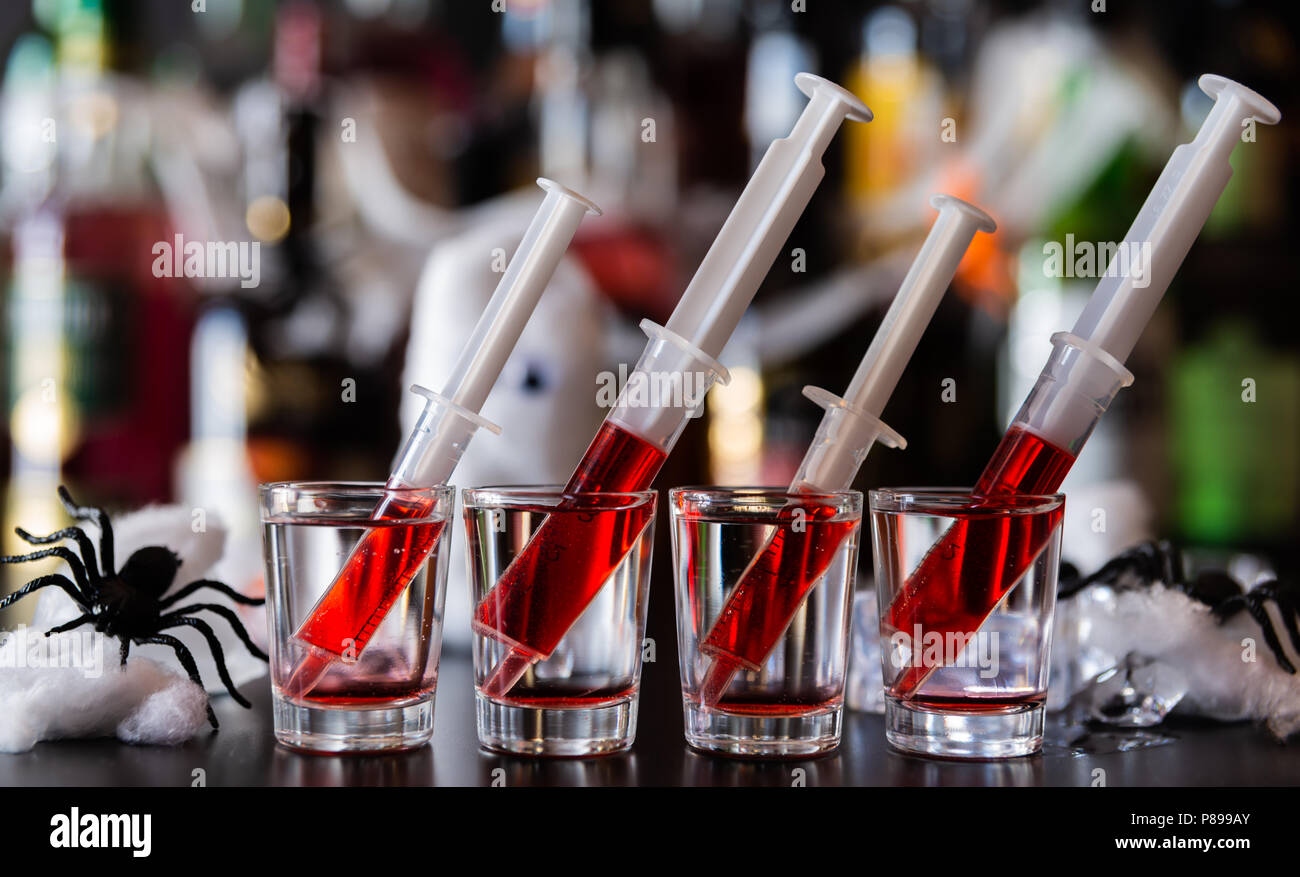 creepy halloween party cocktails with syringes of grenadine syrup as ...