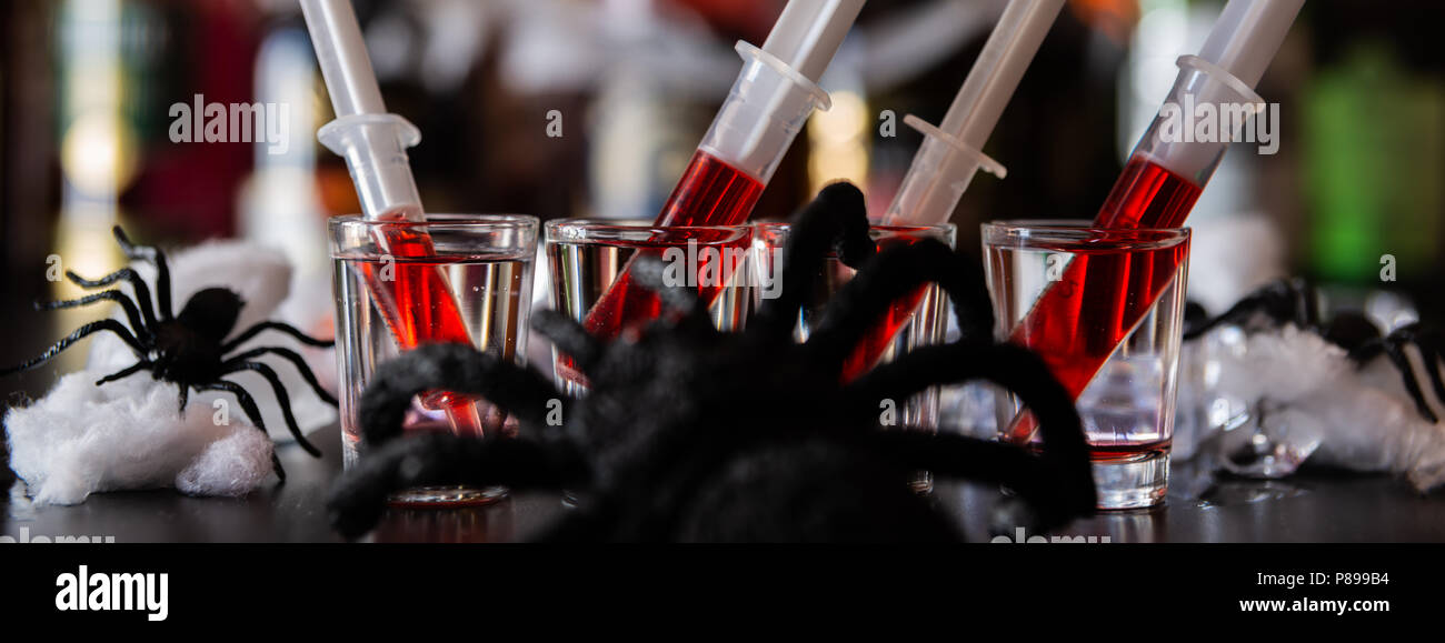 creepy halloween party cocktails with syringes of grenadine syrup as ...