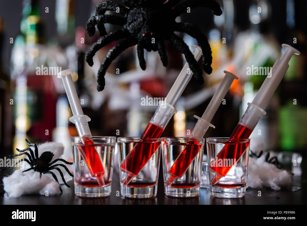 creepy halloween party cocktails with syringes of grenadine syrup as ...