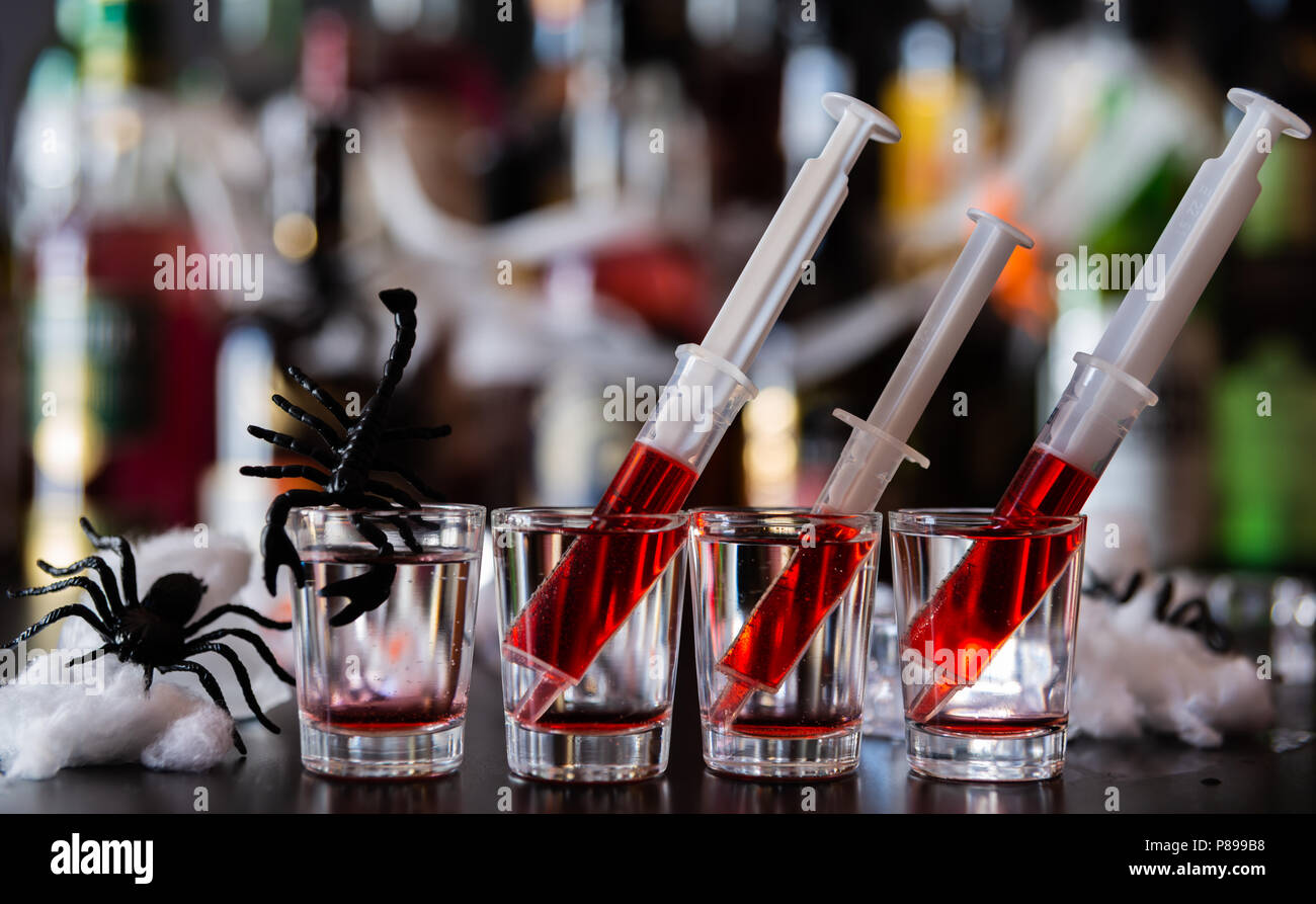 creepy halloween party cocktails with syringes of grenadine syrup as ...