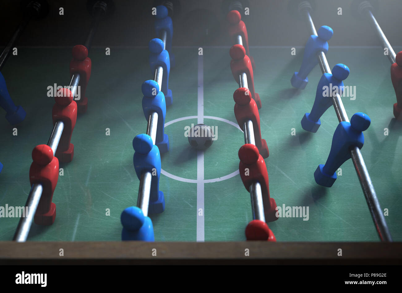 A closeup look of figurines of a foosball table lit by dramatic ...