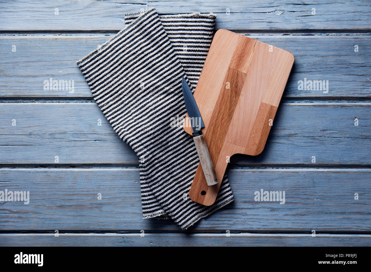 Wooden chopping board and cloth on a rustic wood plank table Stock ...