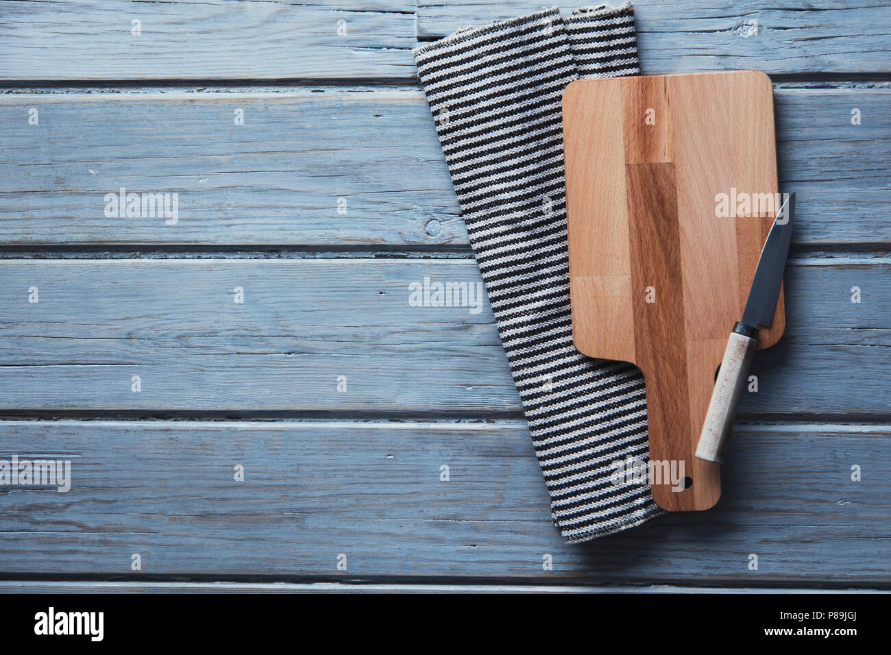 Wooden chopping board and cloth on a rustic wood plank table Stock ...