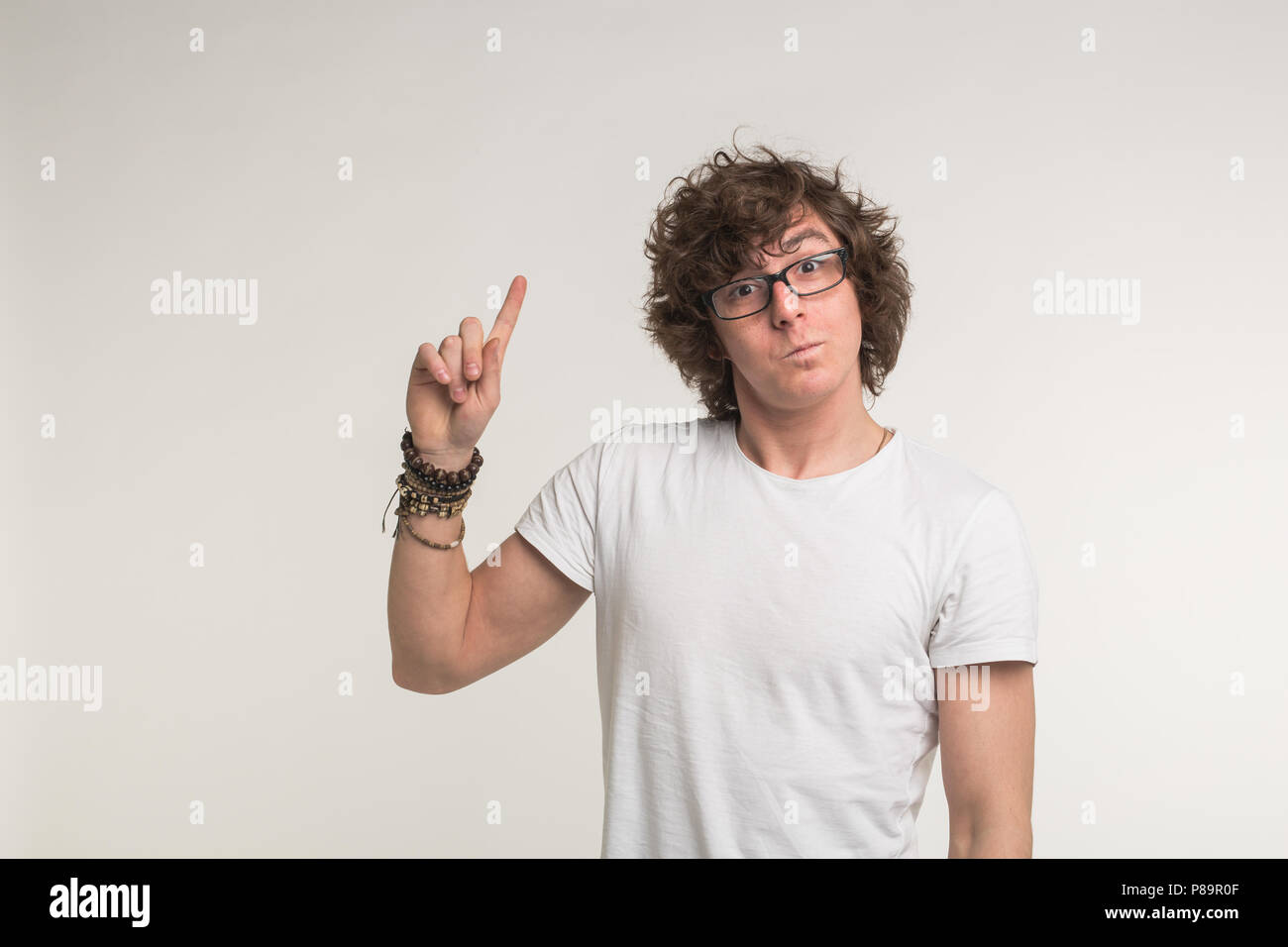 Portrait of a young man having idea and pointing finger up isolated on ...