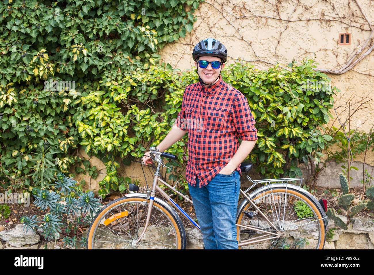 Happy Young Male hold bycycle background green garden Stock Photo - Alamy