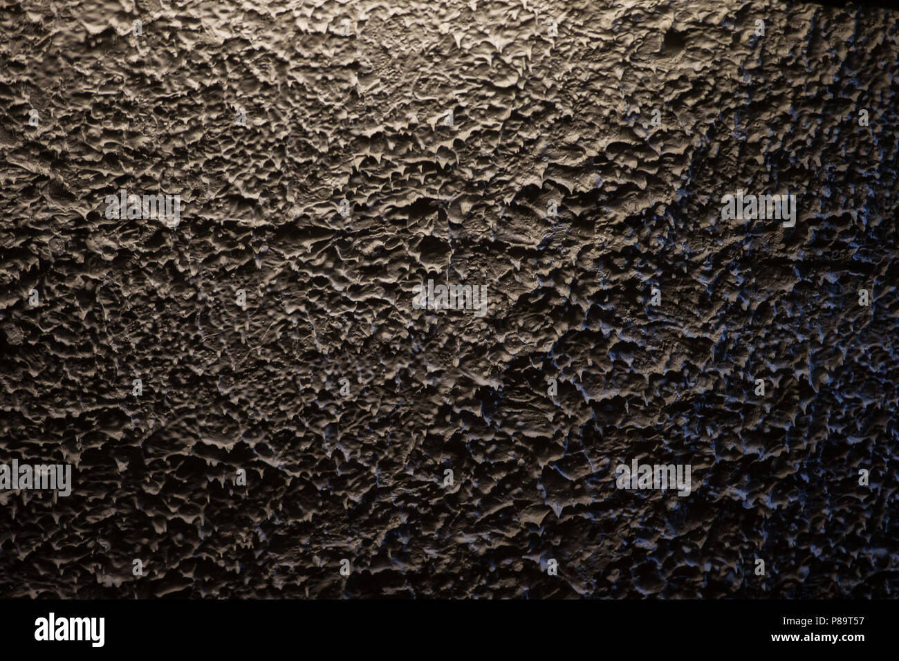Rough dark plaster.The texture of the dark gray plaster is illuminated ...