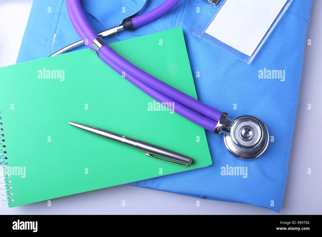 Medical stethoscope lying on a blue doctor's form and notepad close-up ...