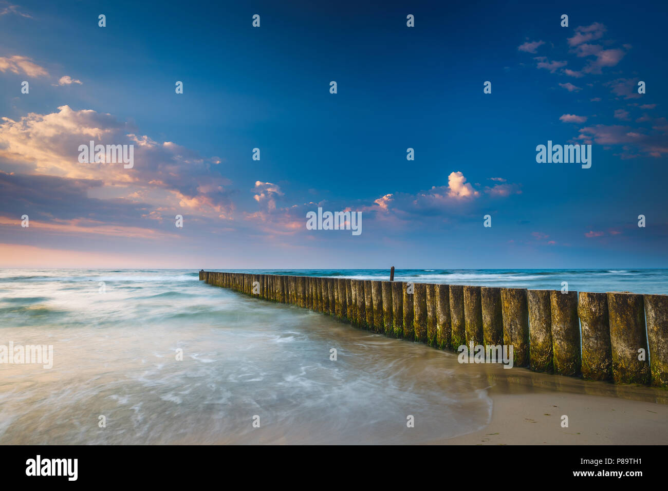 Sunset on the beach with breakwater, long time exposure Stock Photo - Alamy