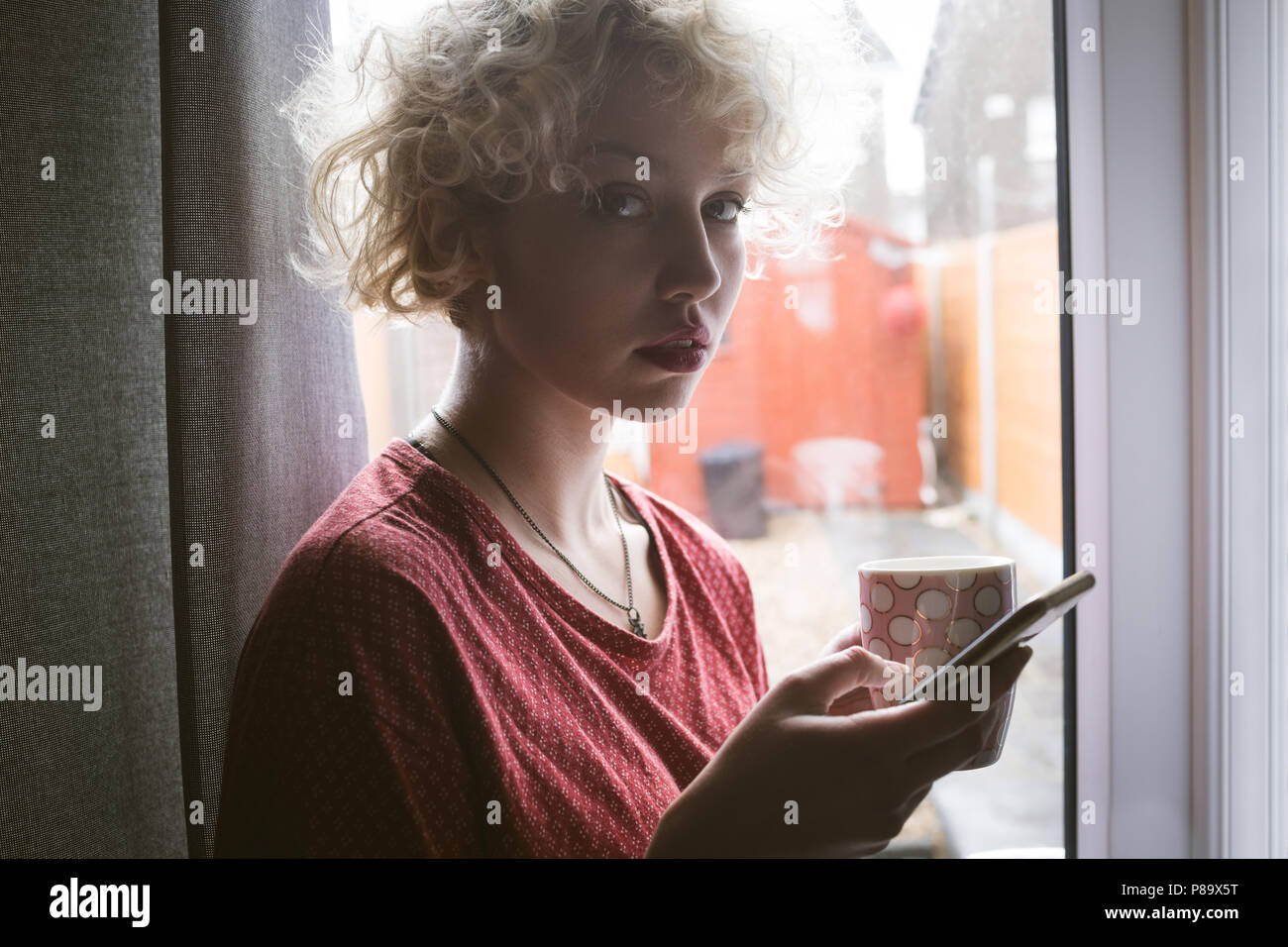 Hipster looking at phone at home hi-res stock photography and images ...