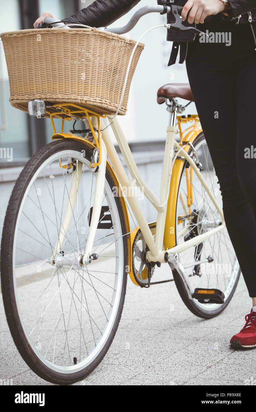 Woman with bicycle walking on pavement Stock Photo - Alamy