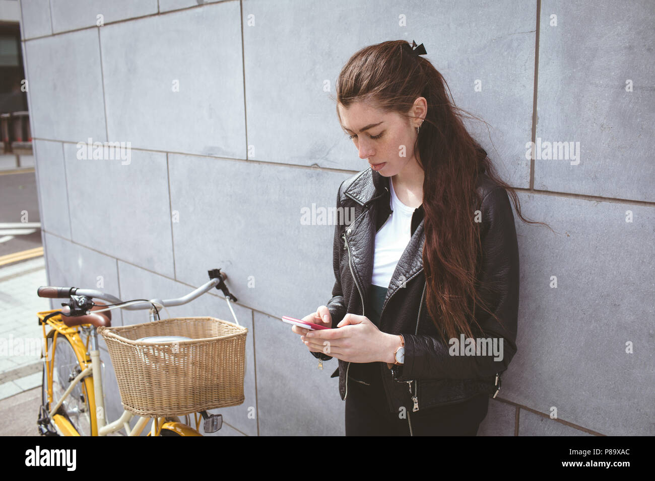 Beautiful woman standing smartphone wall hi-res stock photography and ...