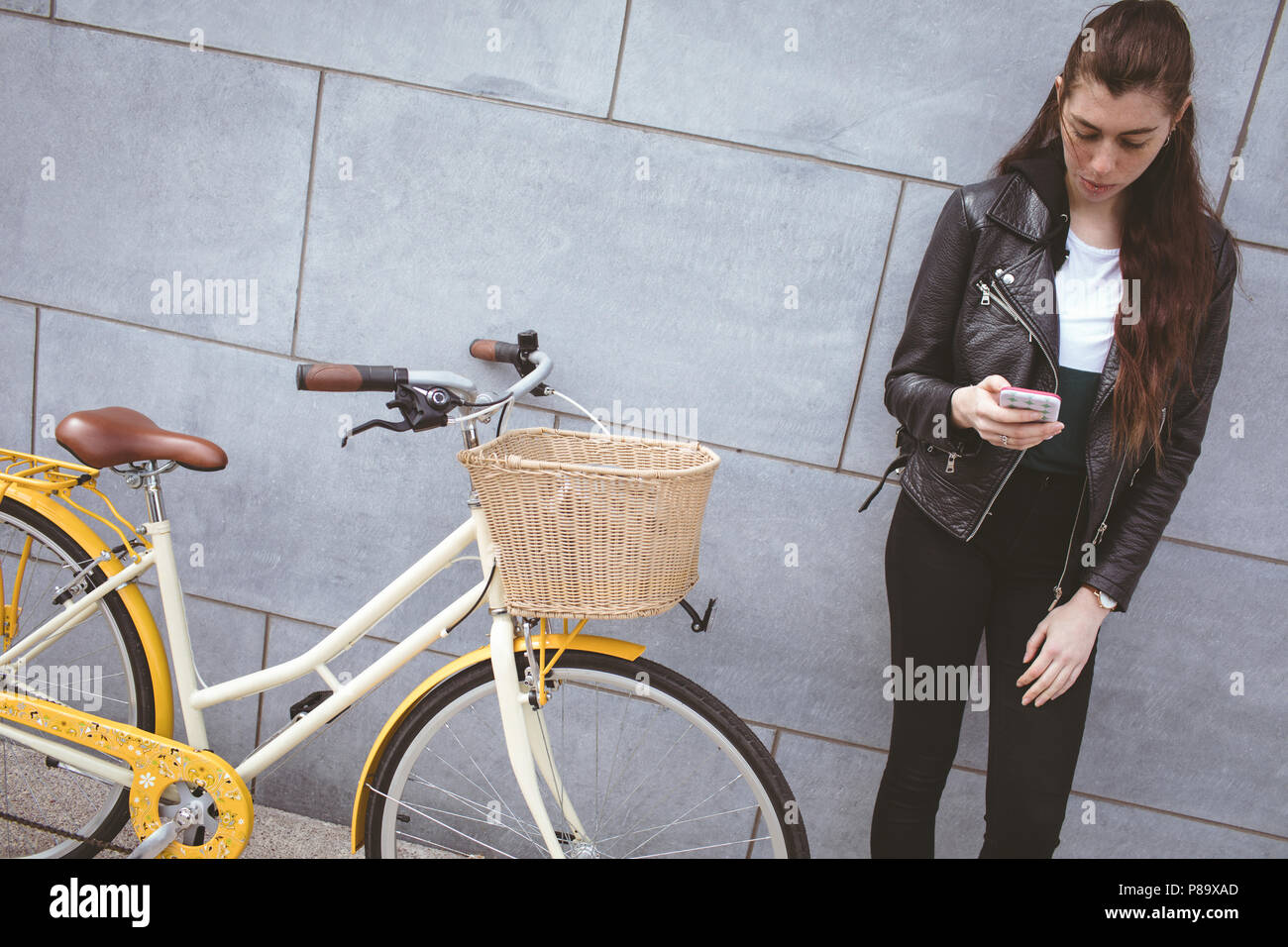 Beautiful woman standing smartphone wall hi-res stock photography and ...
