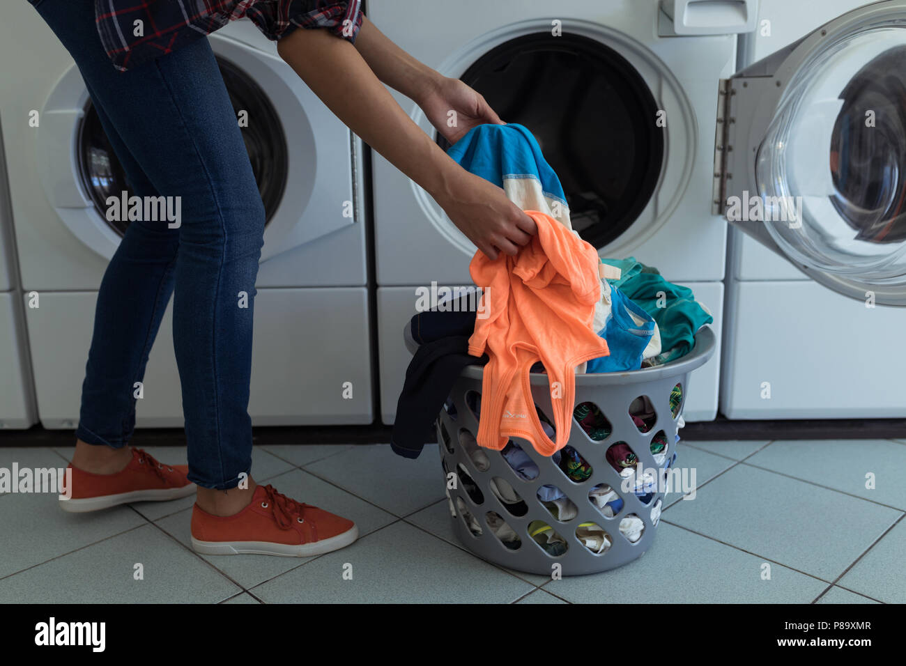 Woman putting laundry in basket hi-res stock photography and images - Alamy