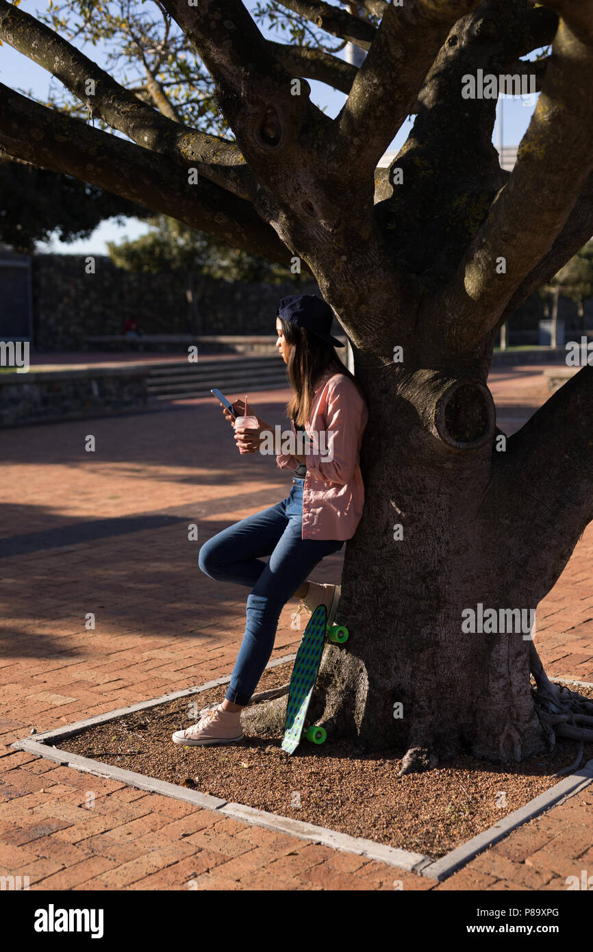 Woman relaxing against tree hi-res stock photography and images - Alamy