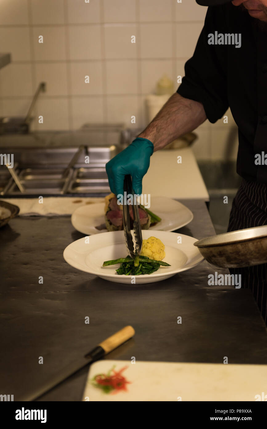 Male chef serving food in a plate Stock Photo - Alamy