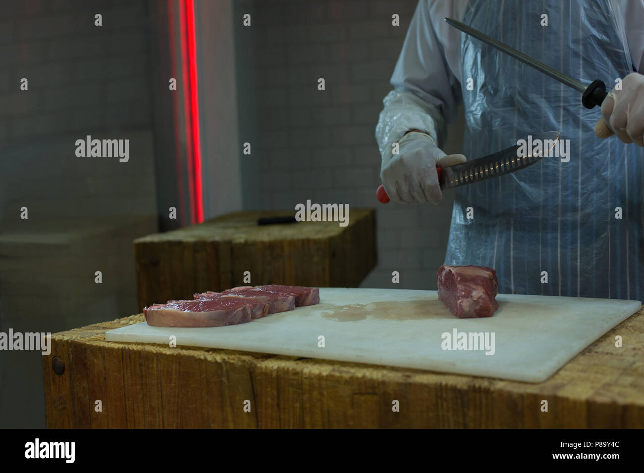 Butcher standing with meat piece at butcher shop Stock Photo - Alamy