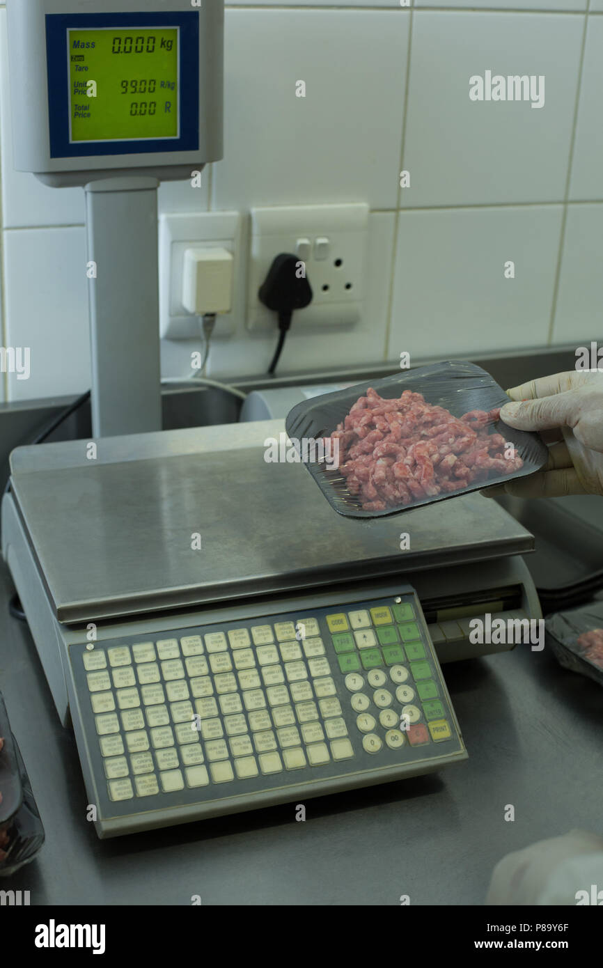 Butcher checking weight of packed meat Stock Photo - Alamy