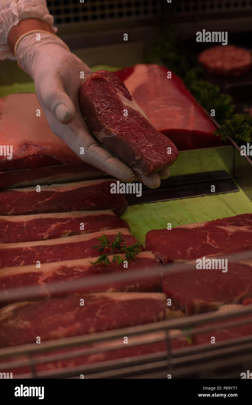 Butcher removing meat from display Stock Photo - Alamy