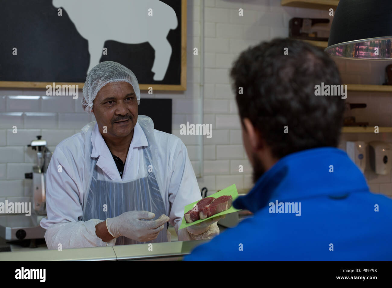 Butcher selling meat in butcher shop Stock Photo - Alamy