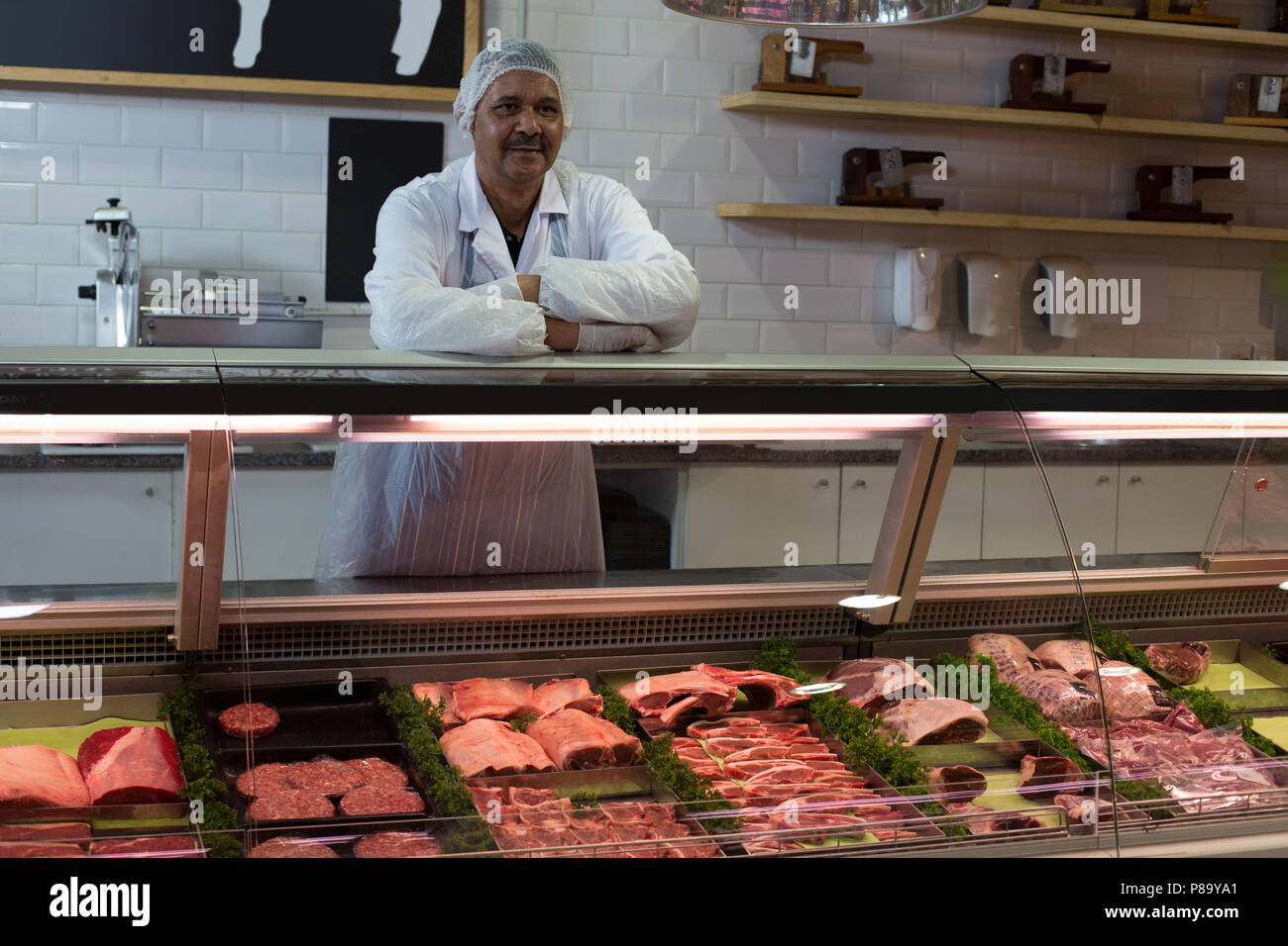 Butcher standing at counter Stock Photo - Alamy