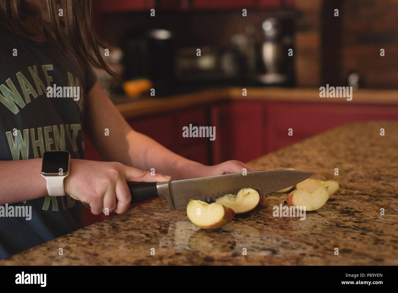 Girl cutting apple in kitchen Stock Photo - Alamy