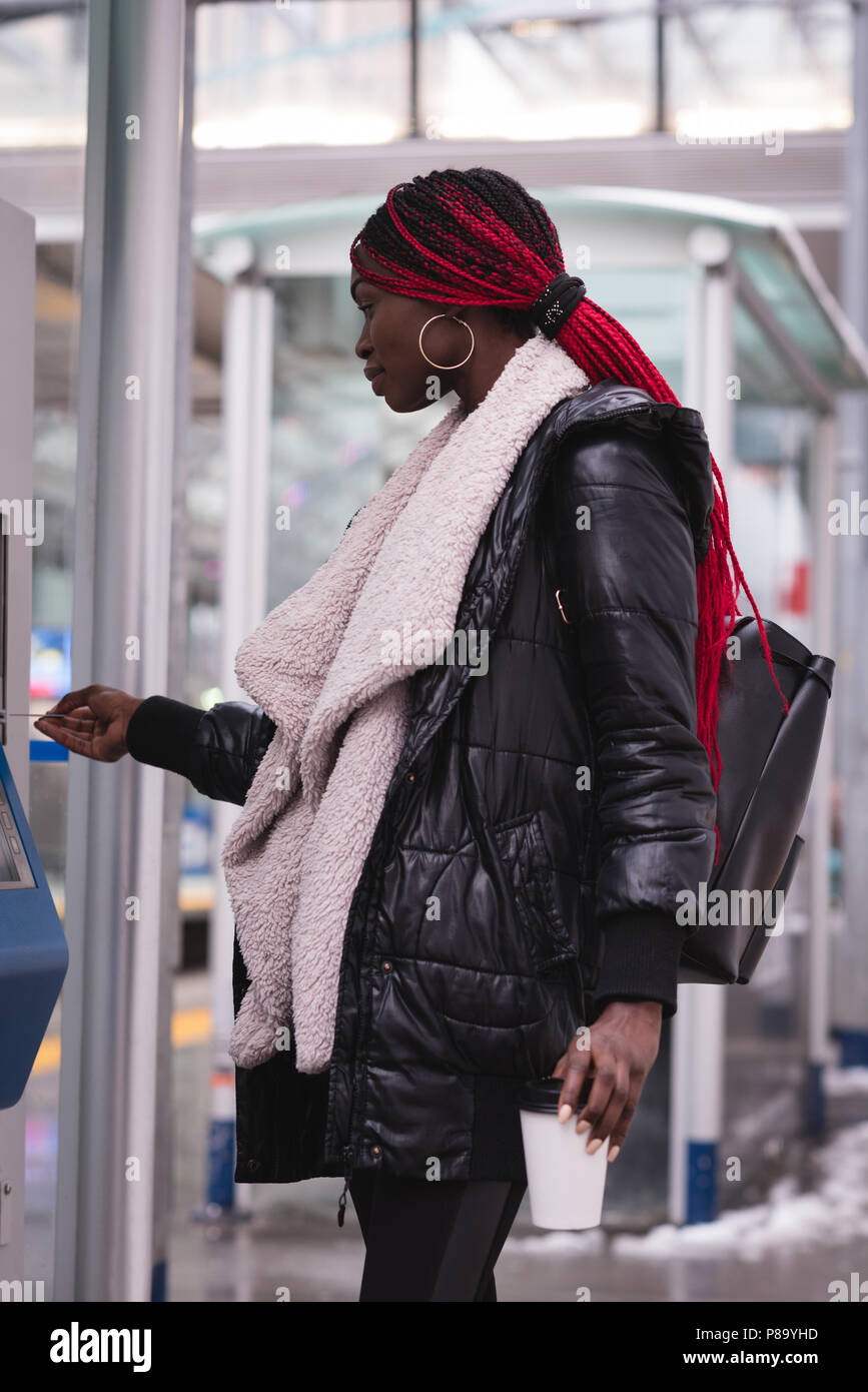 Woman using ticket vending machine at station Stock Photo - Alamy