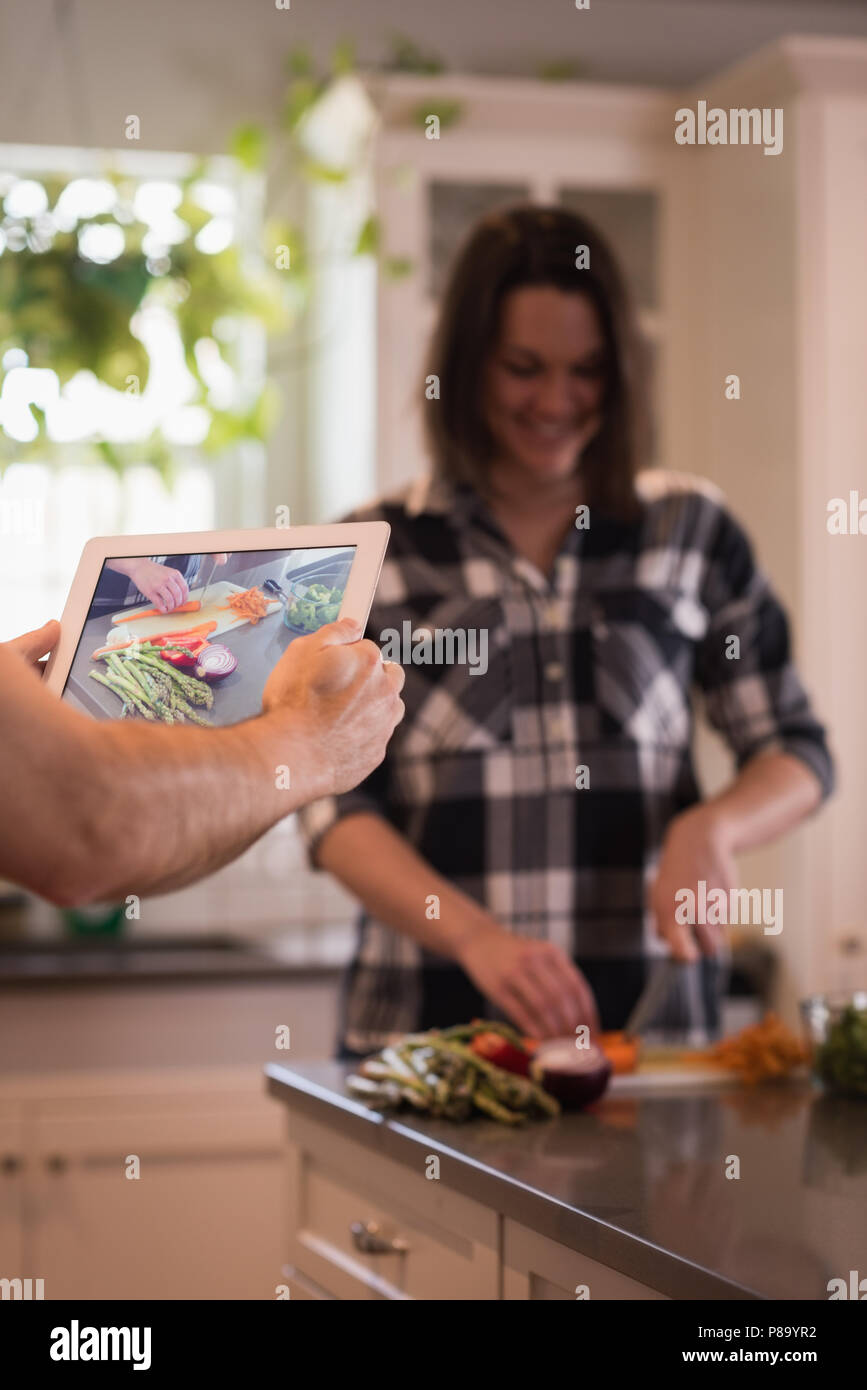 Person photographing woman while cooking food in kitchen Stock Photo ...