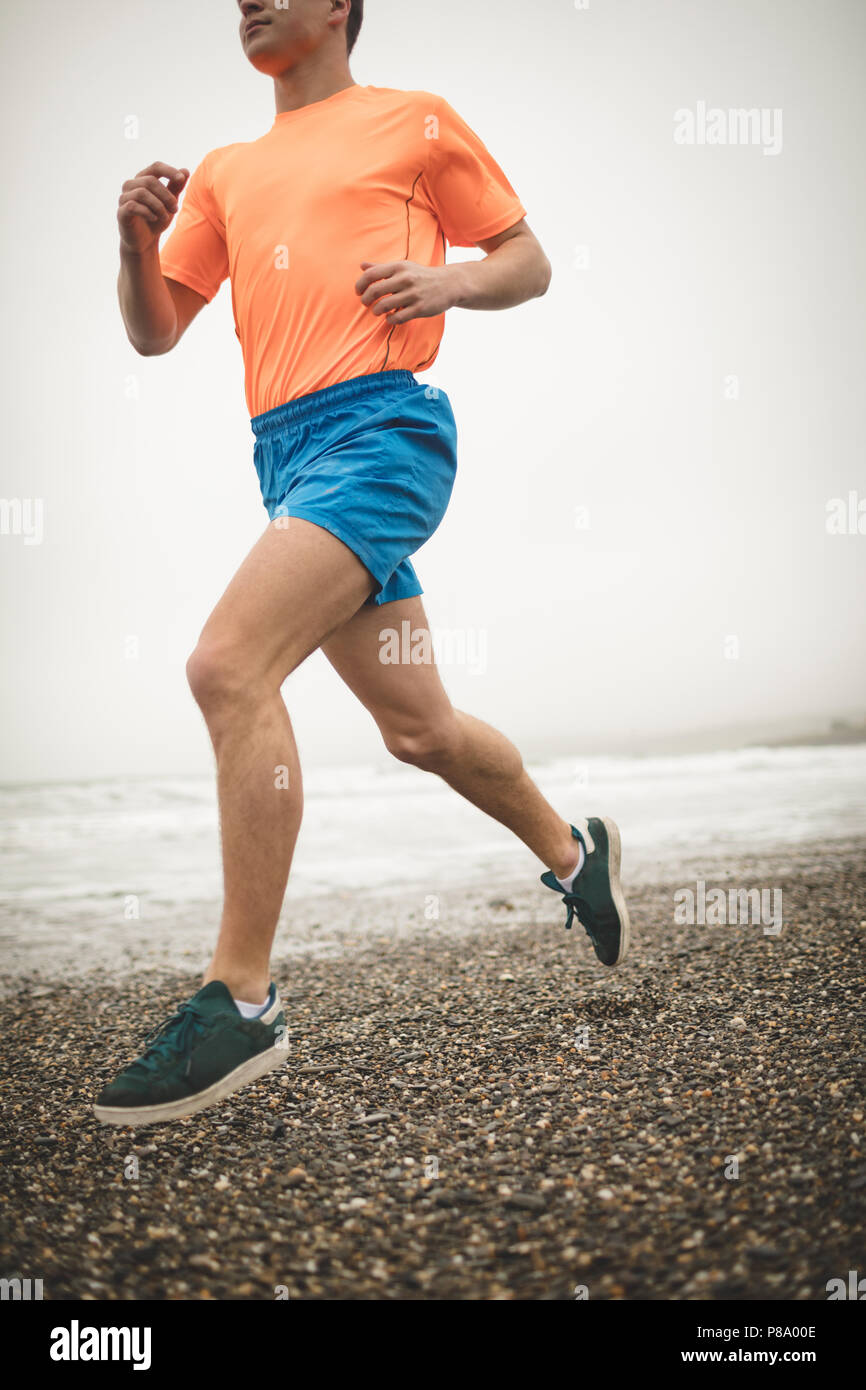 Man jogging on shore at beach Stock Photo - Alamy