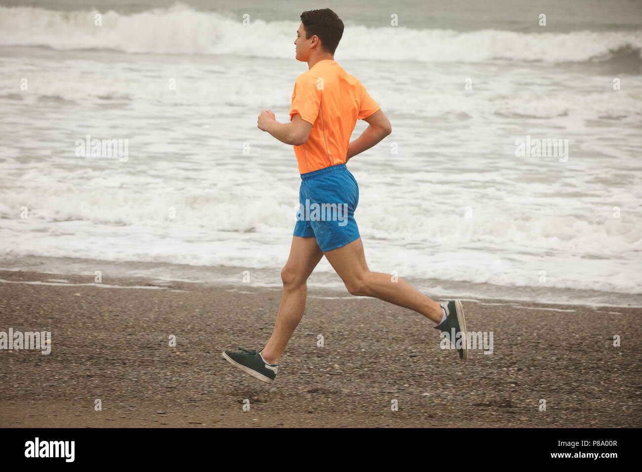 Man jogging on shore at beach Stock Photo - Alamy