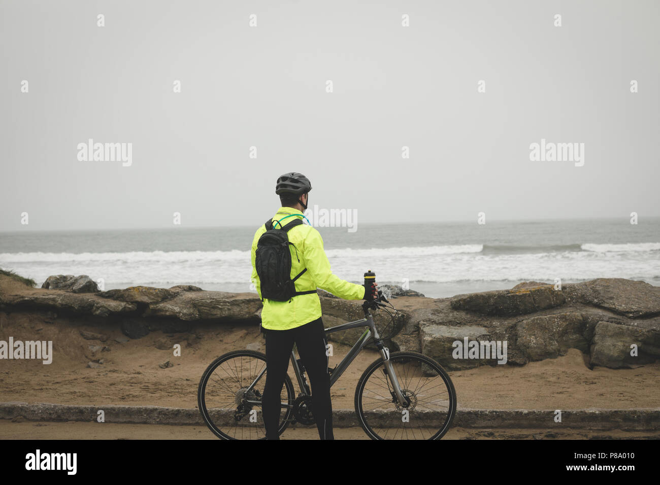 Man with cycle standing at the beach Stock Photo - Alamy