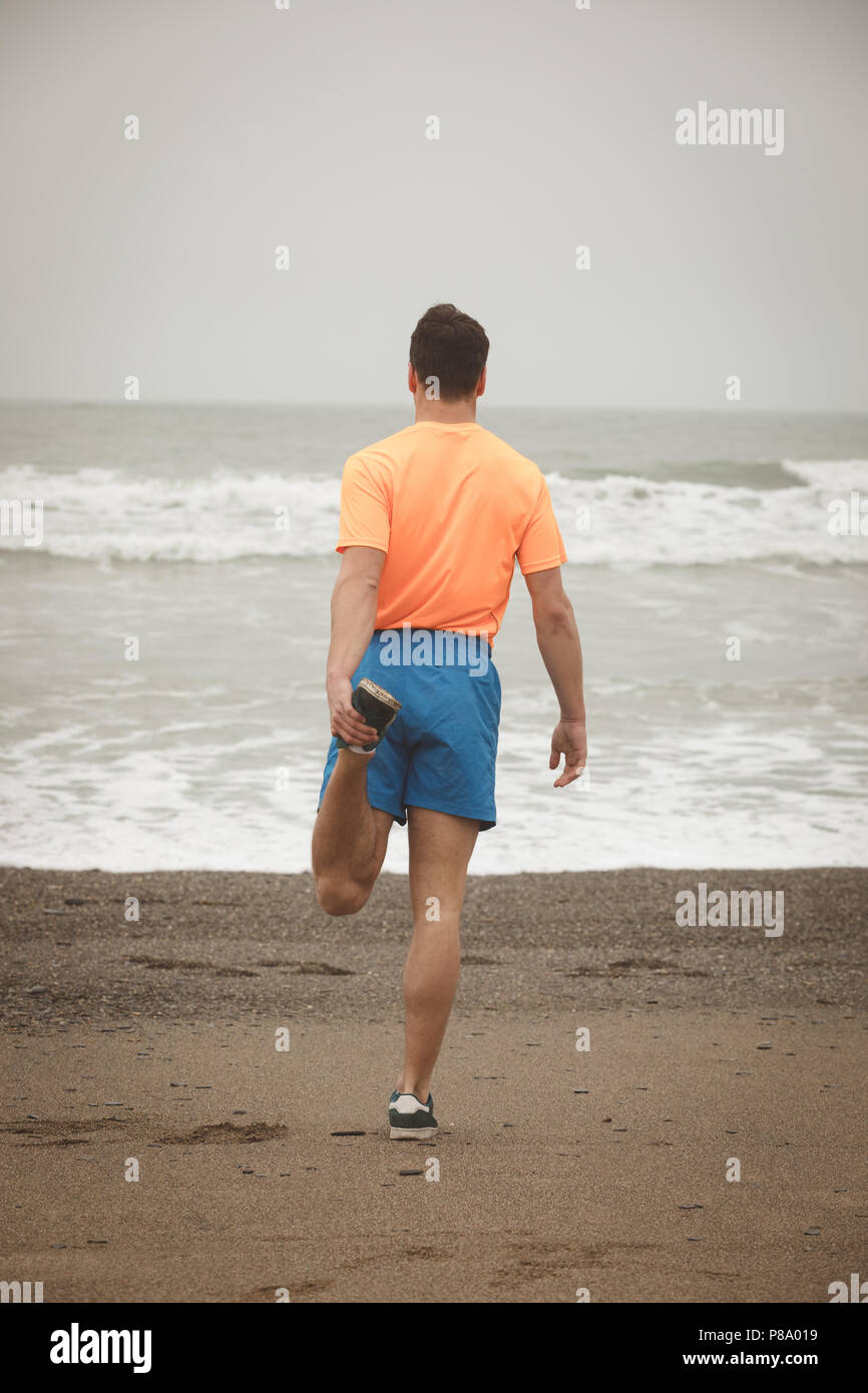 Man stretching on shore at the beach Stock Photo - Alamy