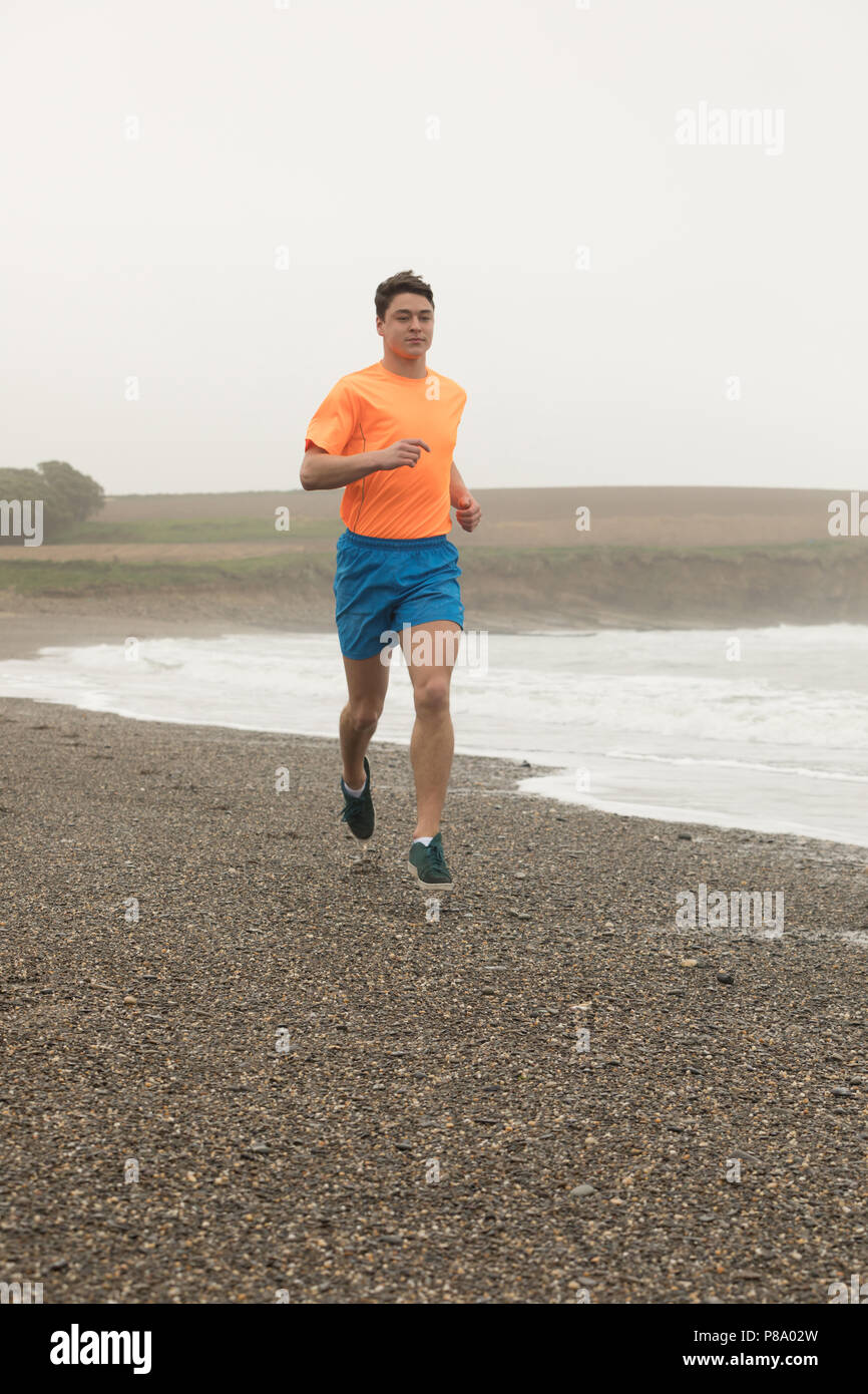 Man jogging on shore at beach Stock Photo - Alamy
