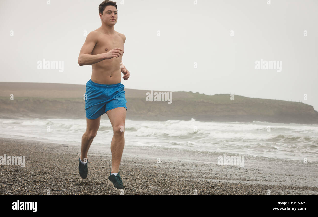 Man jogging on shore at beach Stock Photo - Alamy
