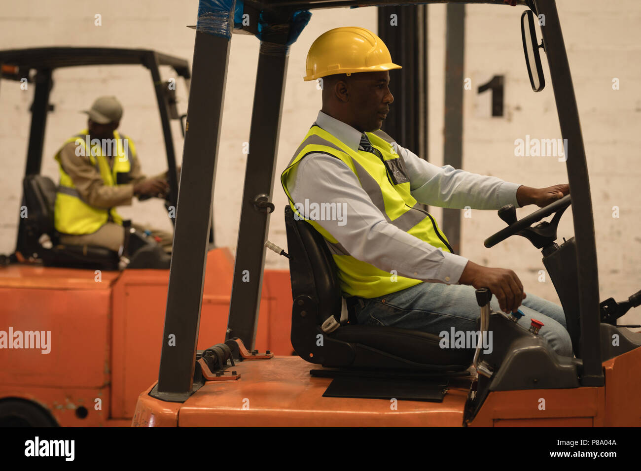 Male worker driving forklift Stock Photo - Alamy