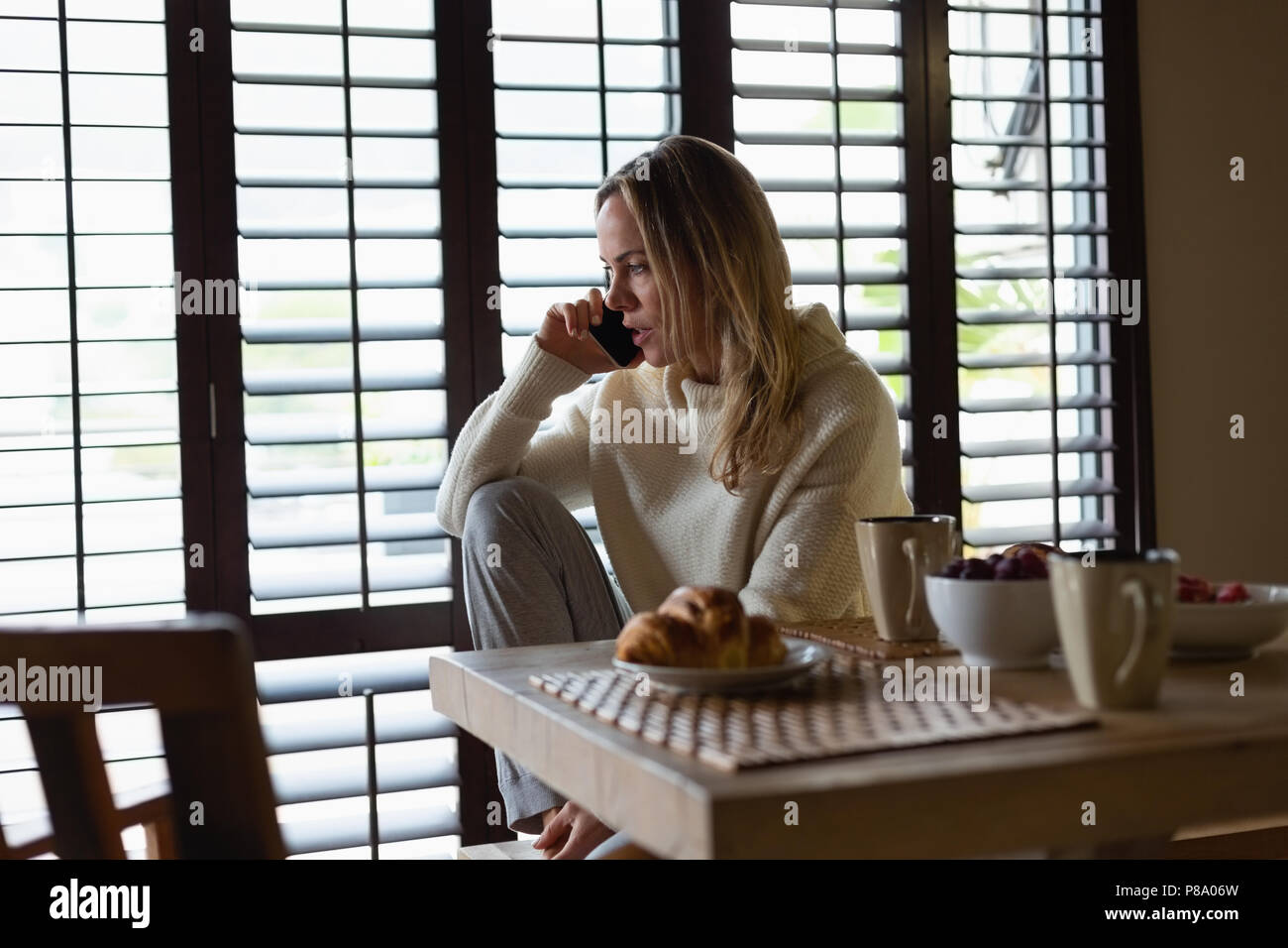 Mature woman sitting on kitchen table hi-res stock photography and ...