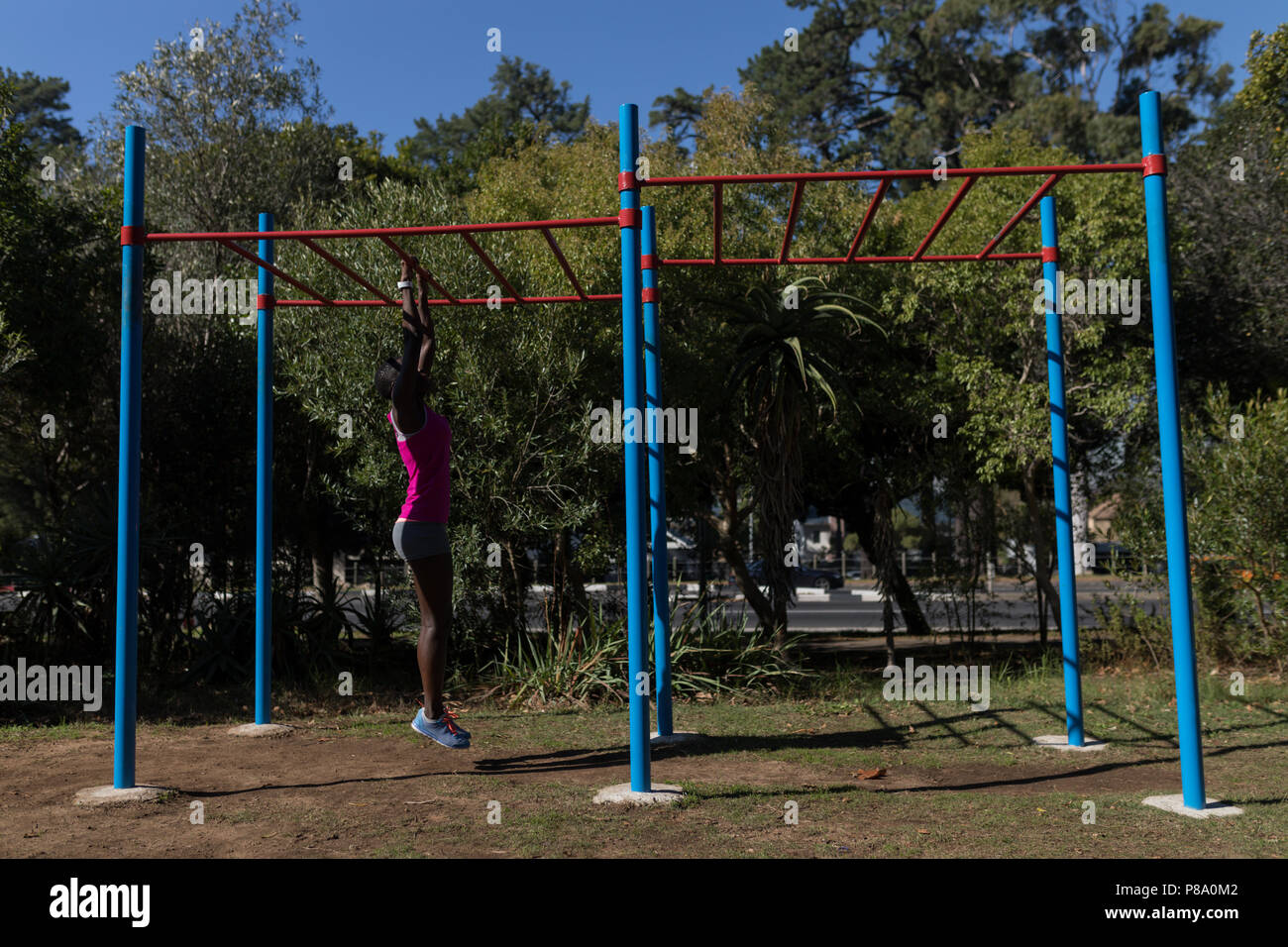 Female athlete exercising on monkey bars Stock Photo - Alamy
