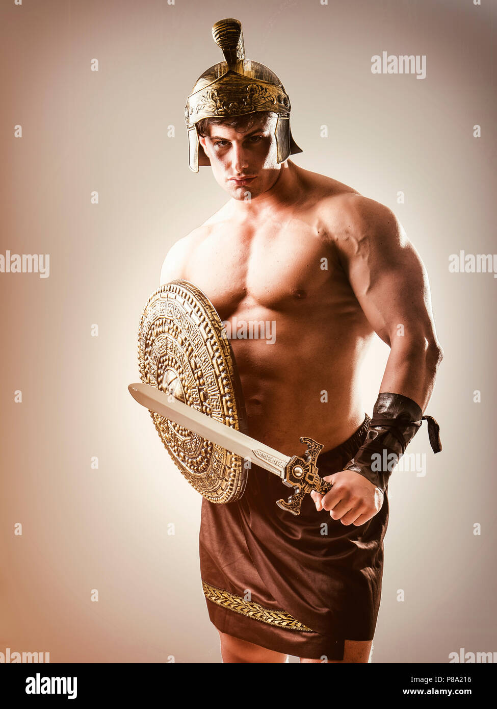 Young muscular man posing in gladiator costume Stock Photo - Alamy