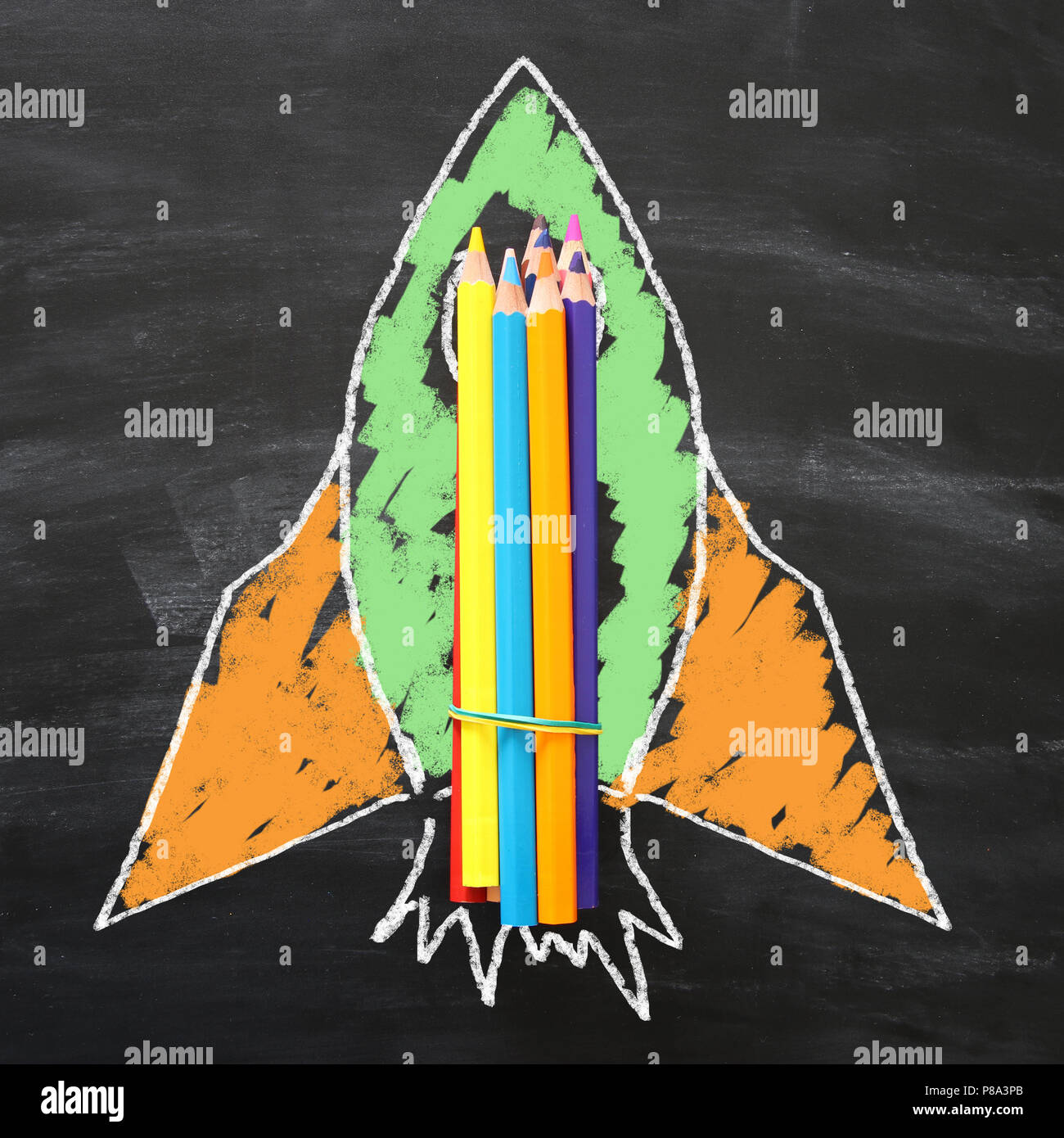 Back to school concept. rocket sketch and pencils over classroom ...