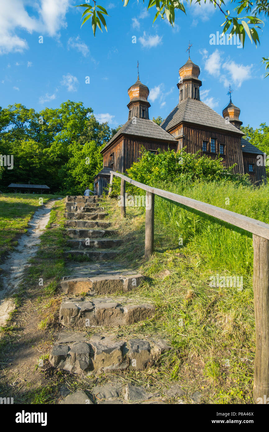 an old wooden church on a hill in the middle of thick green trees ...