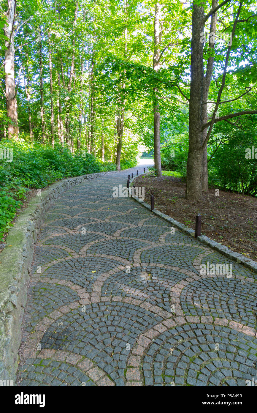 The path in the park is paved with a beautiful pattern running between ...