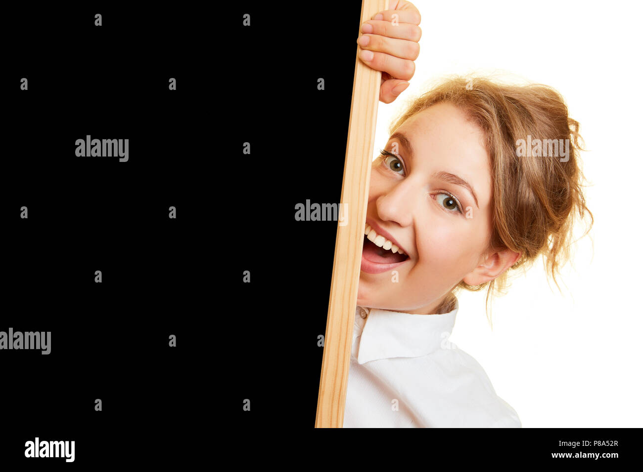 Laughing woman looks out from behind a black chalkboard Stock Photo - Alamy