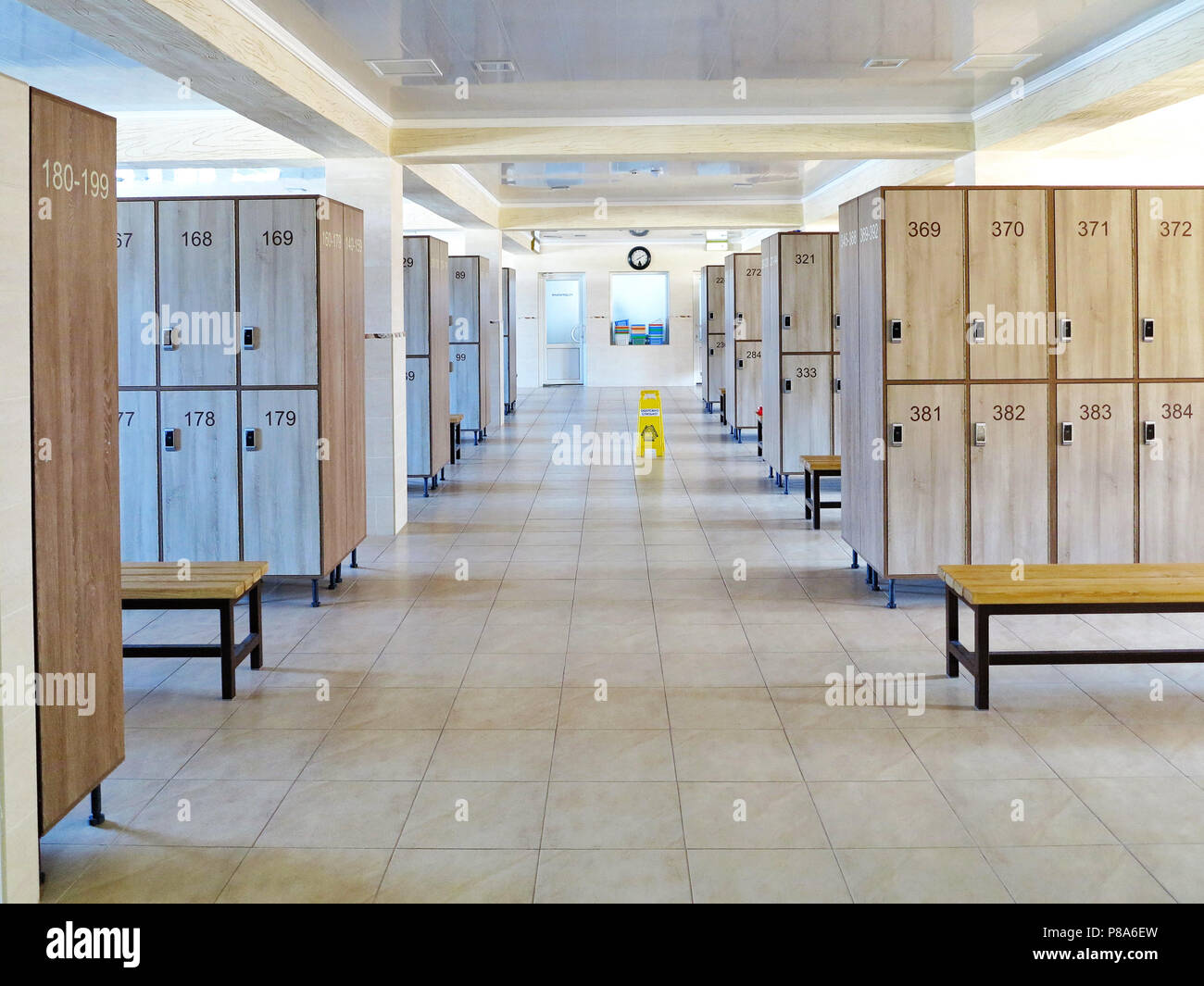 large locker room with lockers and benches on the floor tiled. The ...