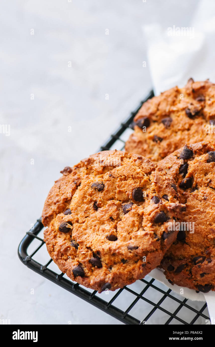 Homemade chocolate chips cookies on a wire rack on a white stone ...