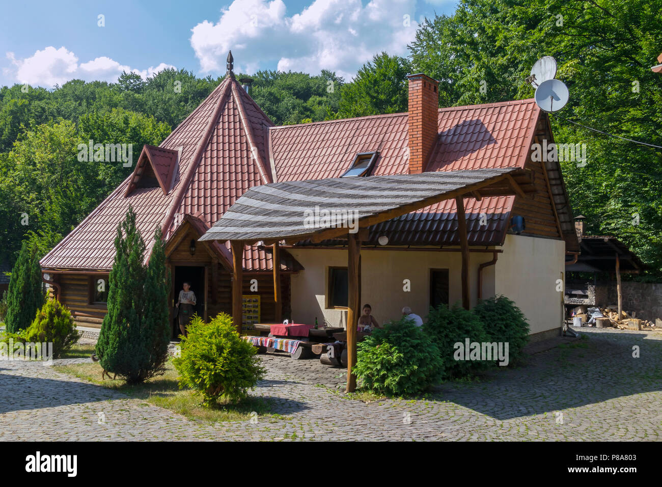 tourists resting under a canopy of a modern type of cafe with a tiled ...