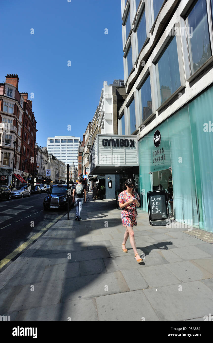 women walking and using mobile phone in street, London, England, UK ...
