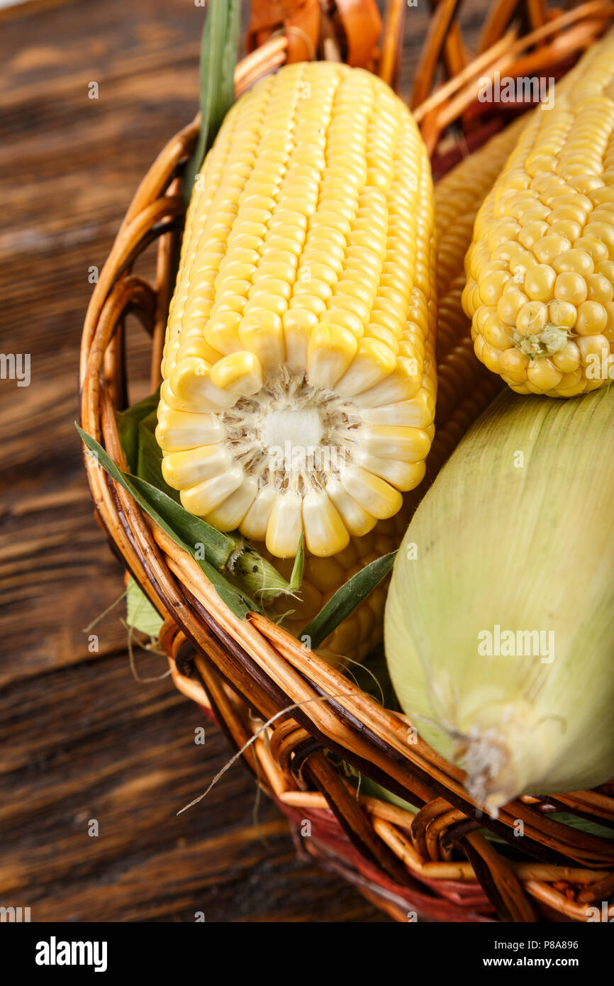 sweet corn on sackcloth, half of corn, some corn peeled, some do not ...