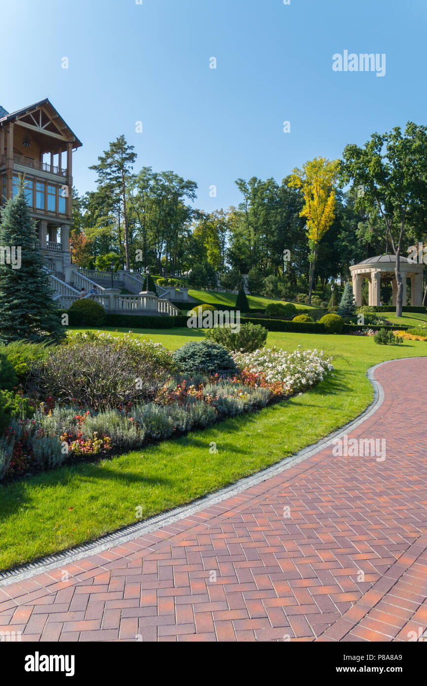 A large country house with an alley leading to a gazebo surrounded by ...
